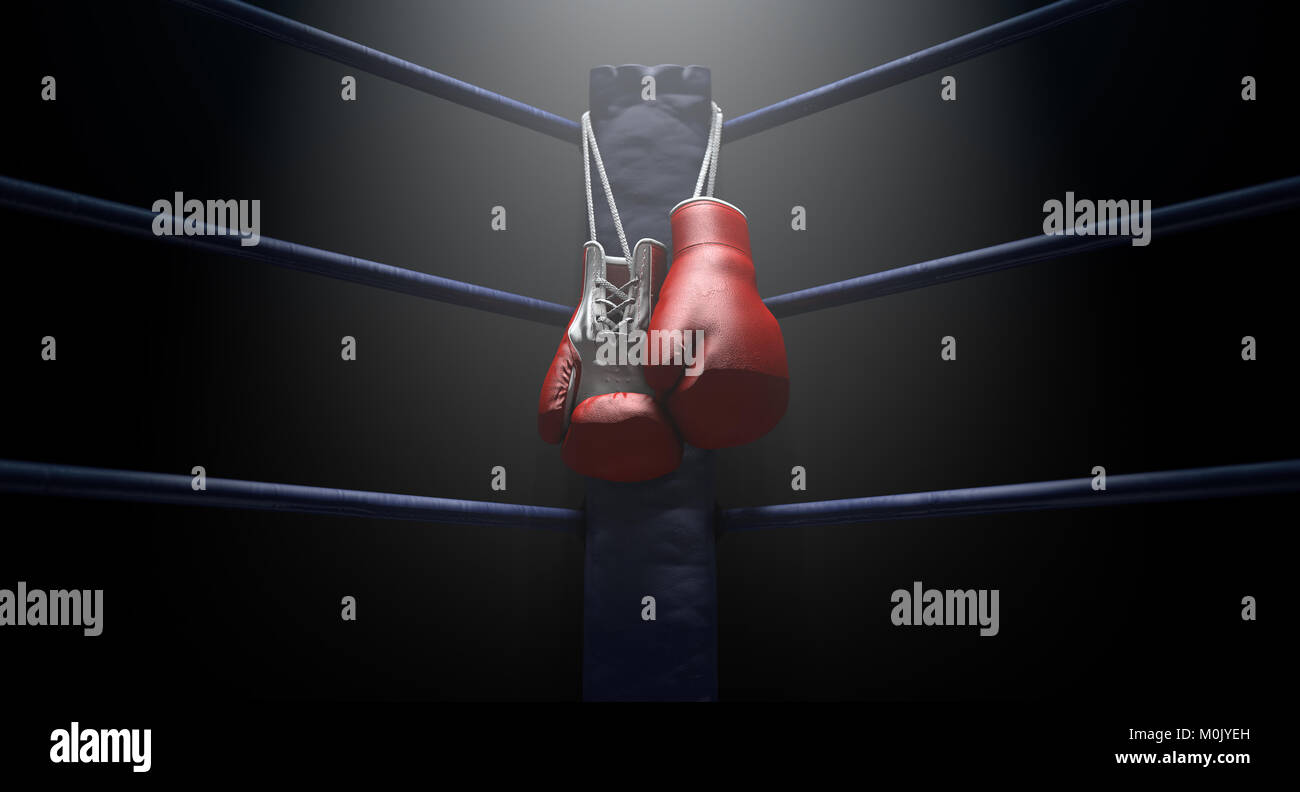 The blue corner of a boxing ring with gloves hanging on a pole spotlit ...