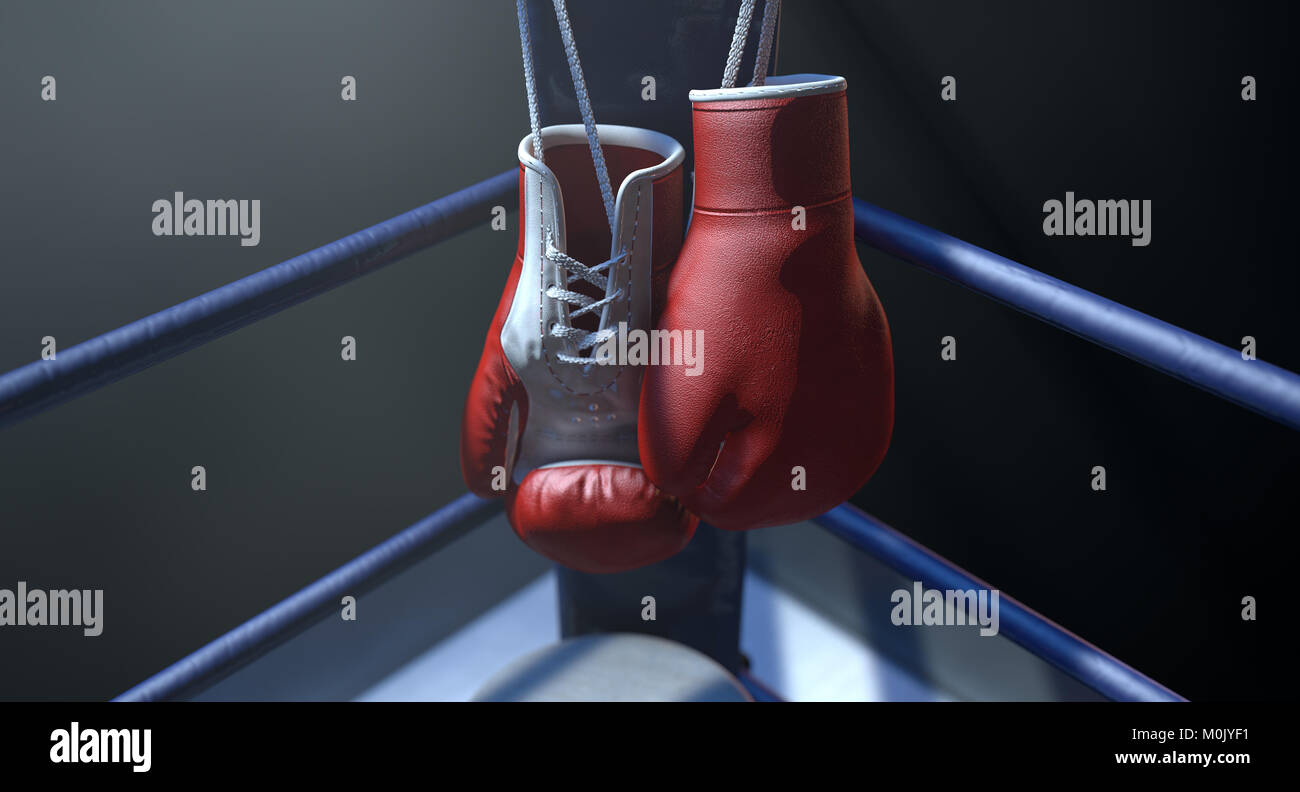 The blue corner of a boxing ring with gloves hanging on a pole spotlit ...