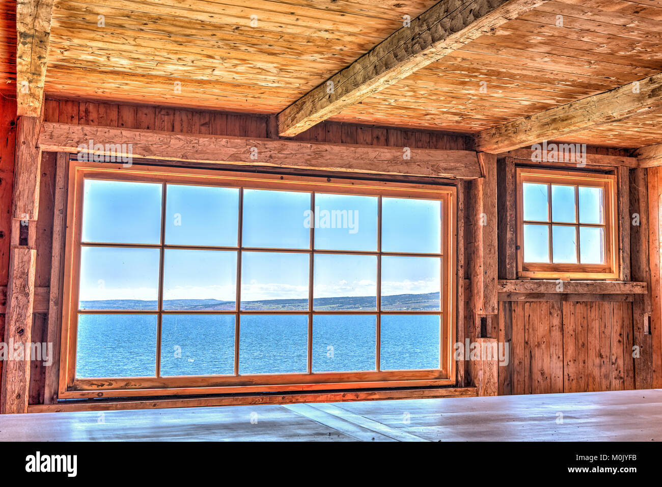 Looking through old window of house with cliff and ocean view in ...