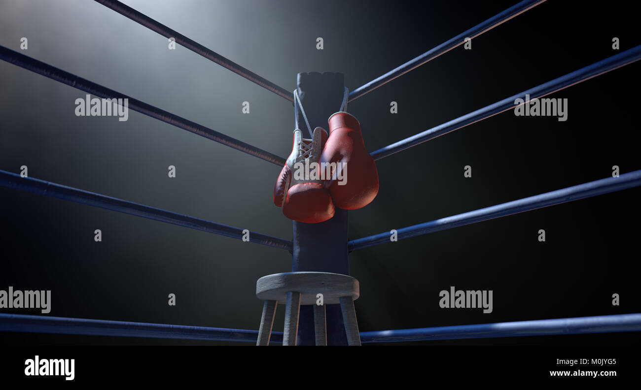 The blue corner of a boxing ring with gloves hanging on a pole spotlit ...