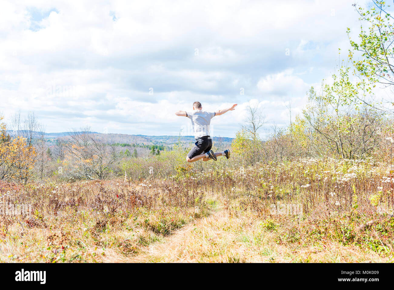 Young athletic, fit, free happy man running jogging jumping in autumn ...