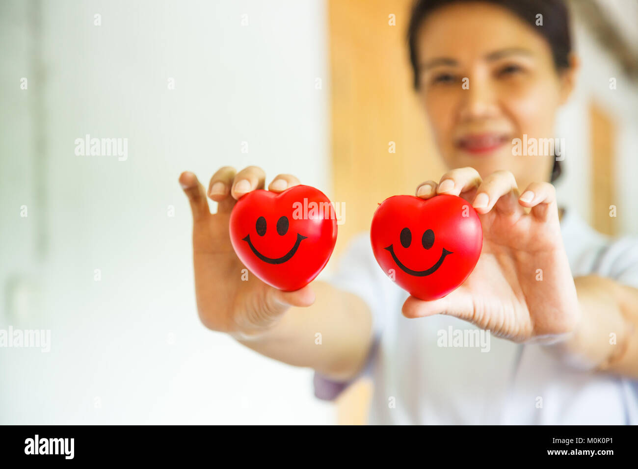 Two Red Smiling Hearts held by smiling female nurse's hands ...