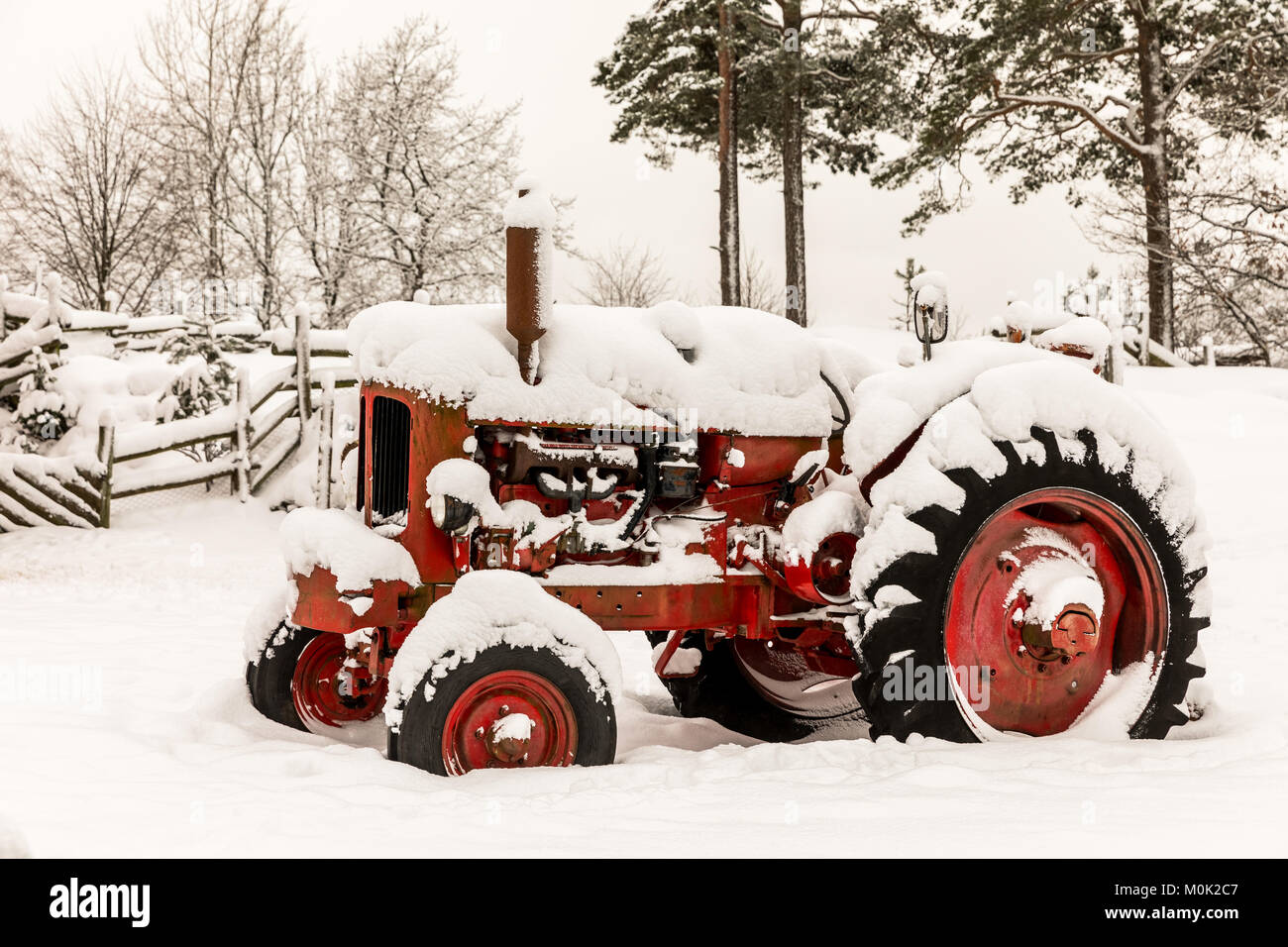 Old red tractor covered in snow Stock Photo - Alamy