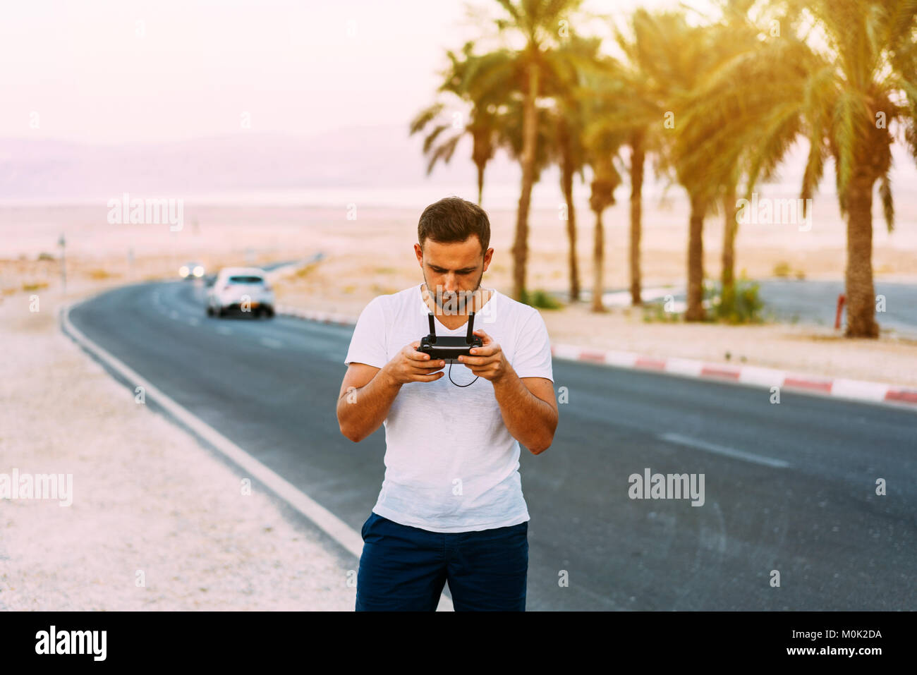 Guy controls drone with remote control Stock Photo - Alamy