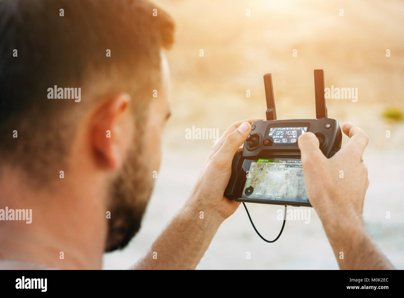 Guy controls drone with remote control Stock Photo - Alamy