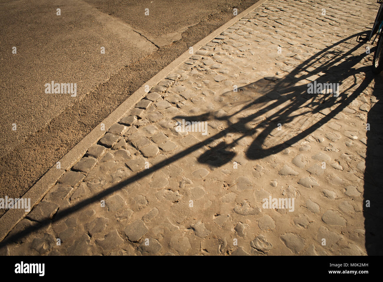 Bicycle shadow on the street during sunset Stock Photo - Alamy