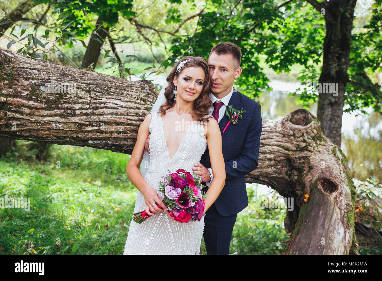 Groom hugging his bride in park. Wedding couple Stock Photo - Alamy