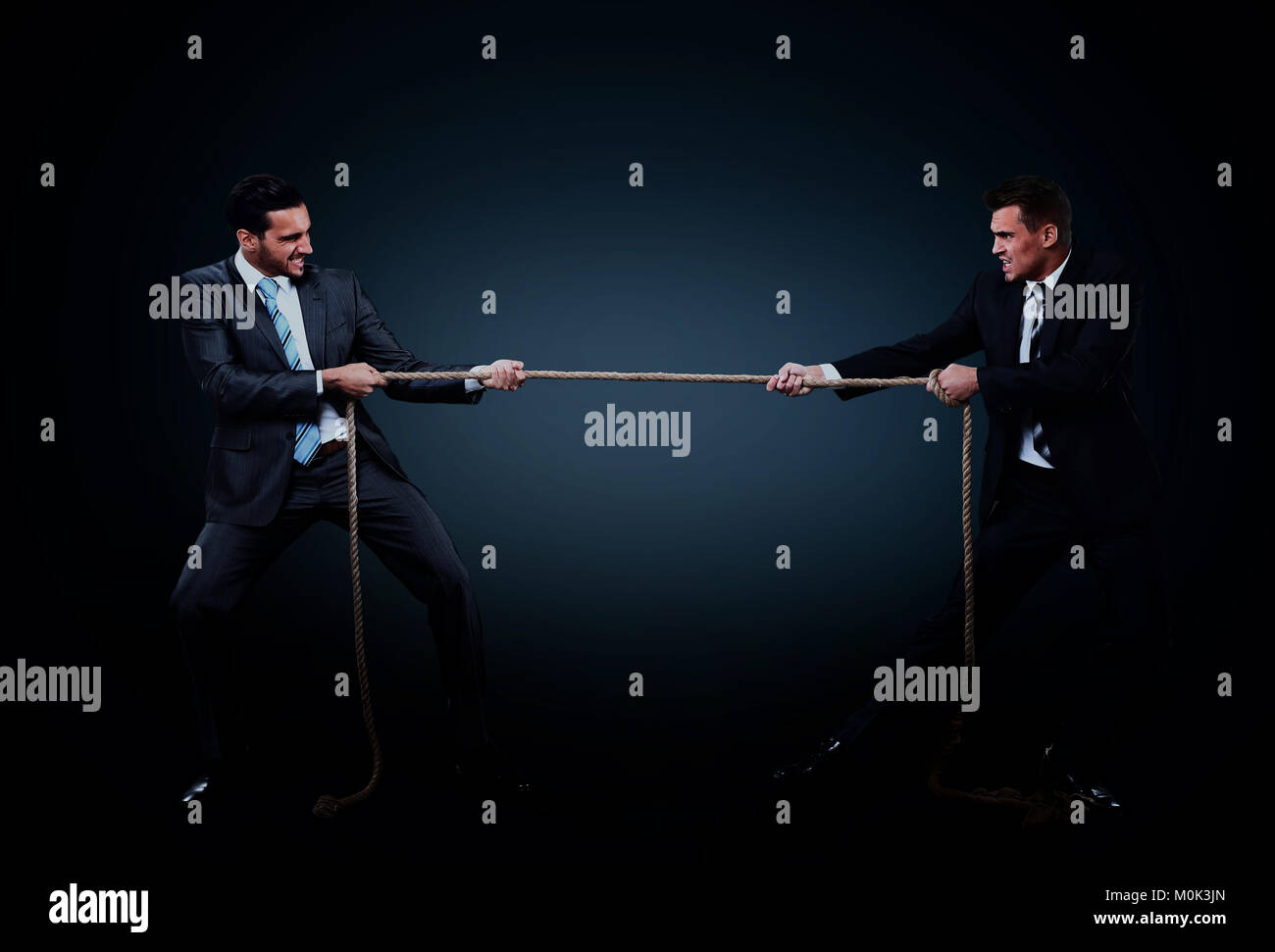 Two business men pulling rope in a competition Stock Photo - Alamy