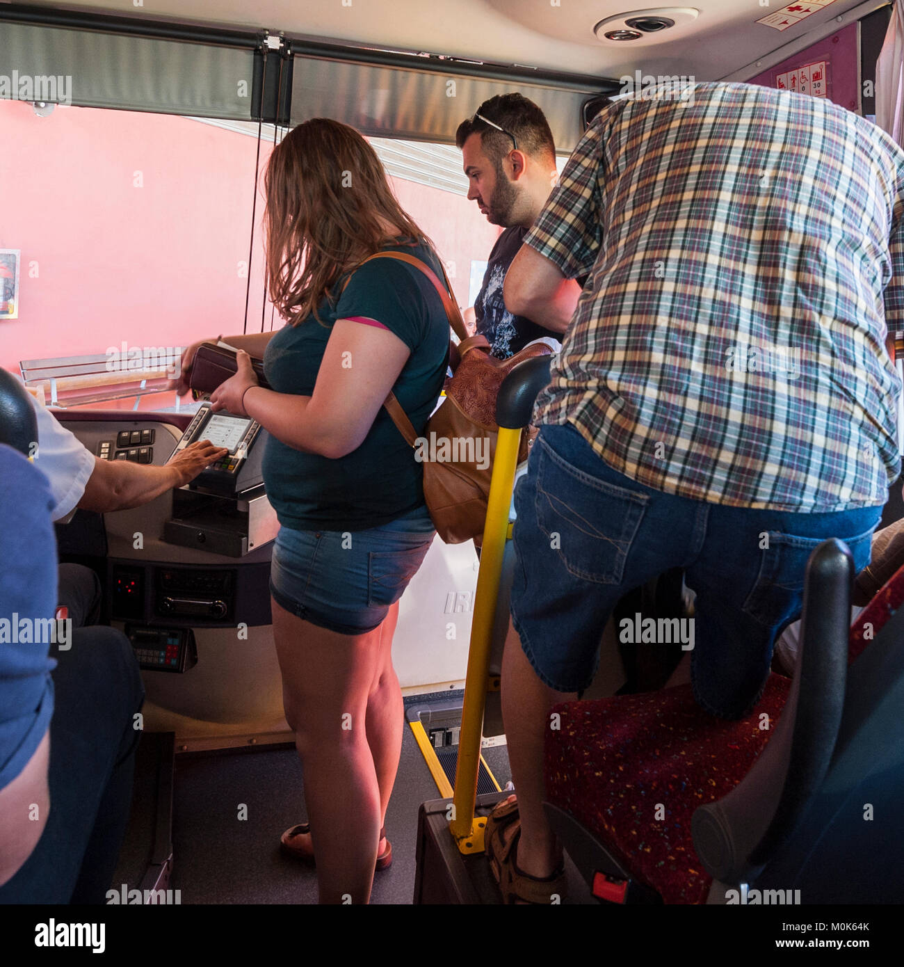 Passengers boarding a public transport bus at the bus station in Mahon ...