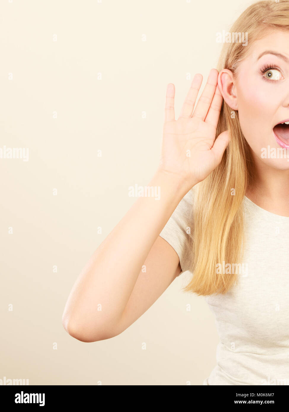 Gossip,rumors, whisper, hearing concept. Young blonde Woman putting ...