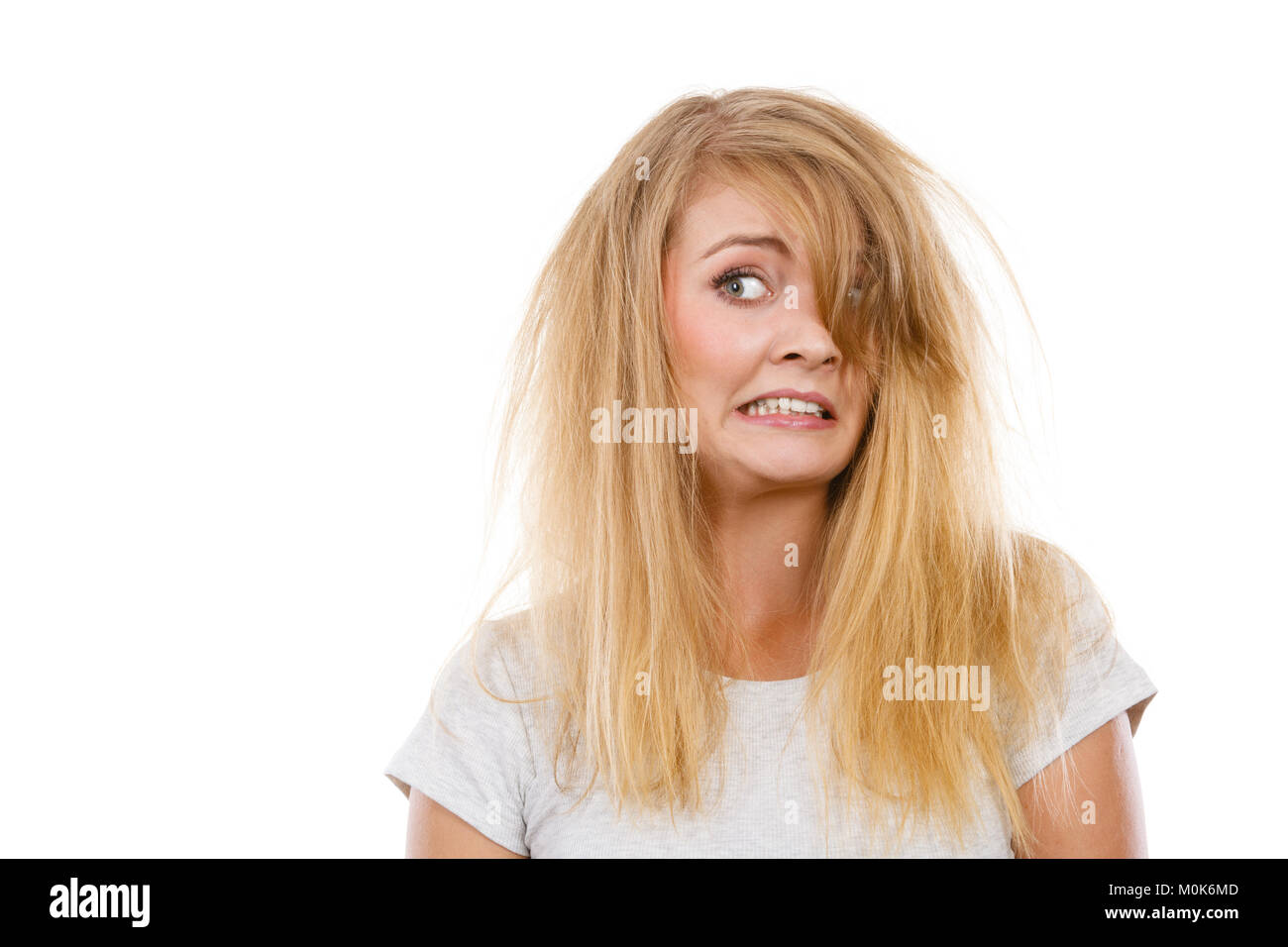 Bad hairstyle concept. Crazy, mad blonde woman with messy hair looking ...