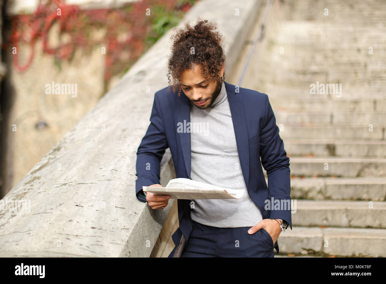 Upset guy reading newspaper outdoor Stock Photo - Alamy