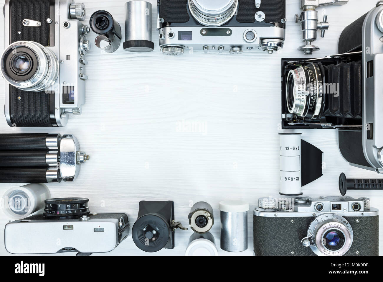 vintage retro photo cameras, film rolls, lens, tripods on white wooden ...