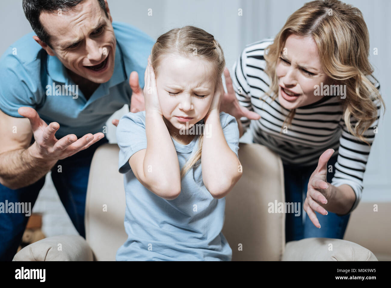 Unsmiling girl and her parents shouting at her Stock Photo - Alamy