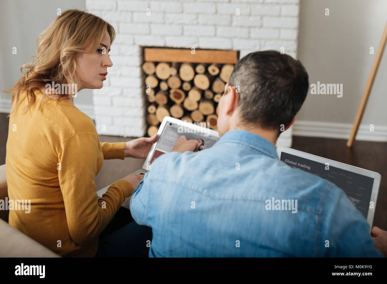 Serious young lady discussing work with her man Stock Photo - Alamy
