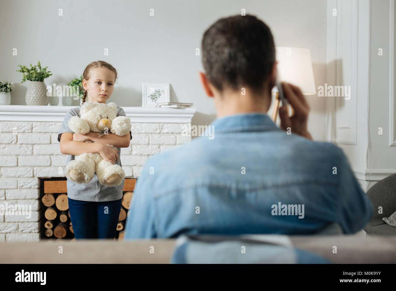 Miserable child watching her father talking on the phone Stock Photo ...