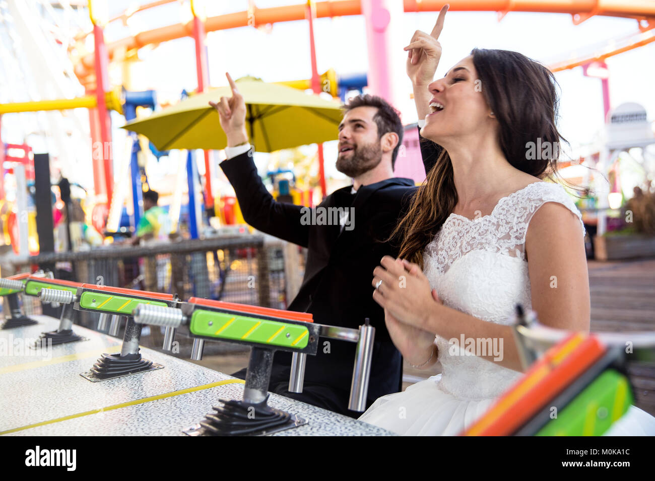 Just newly married bride and groom playing games at carnival enjoying ...