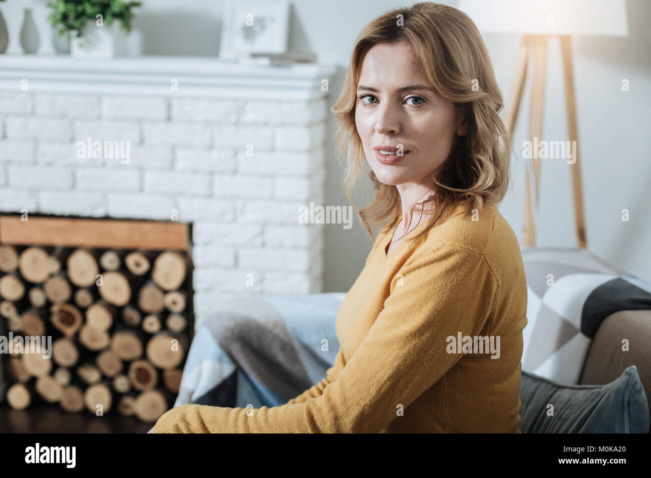 Alert young woman sitting and thinking Stock Photo - Alamy