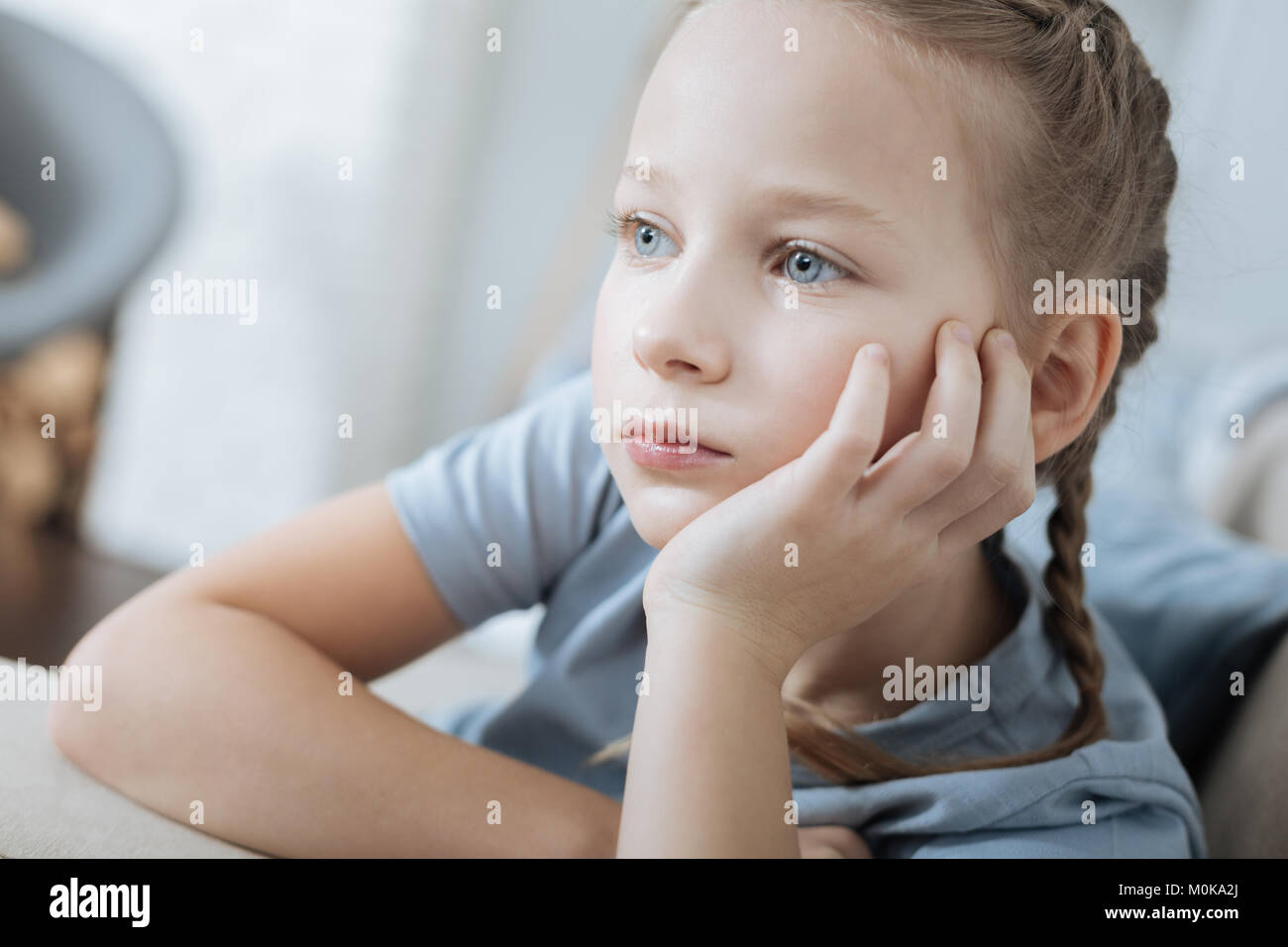 Preoccupied girl sitting and thinking Stock Photo - Alamy