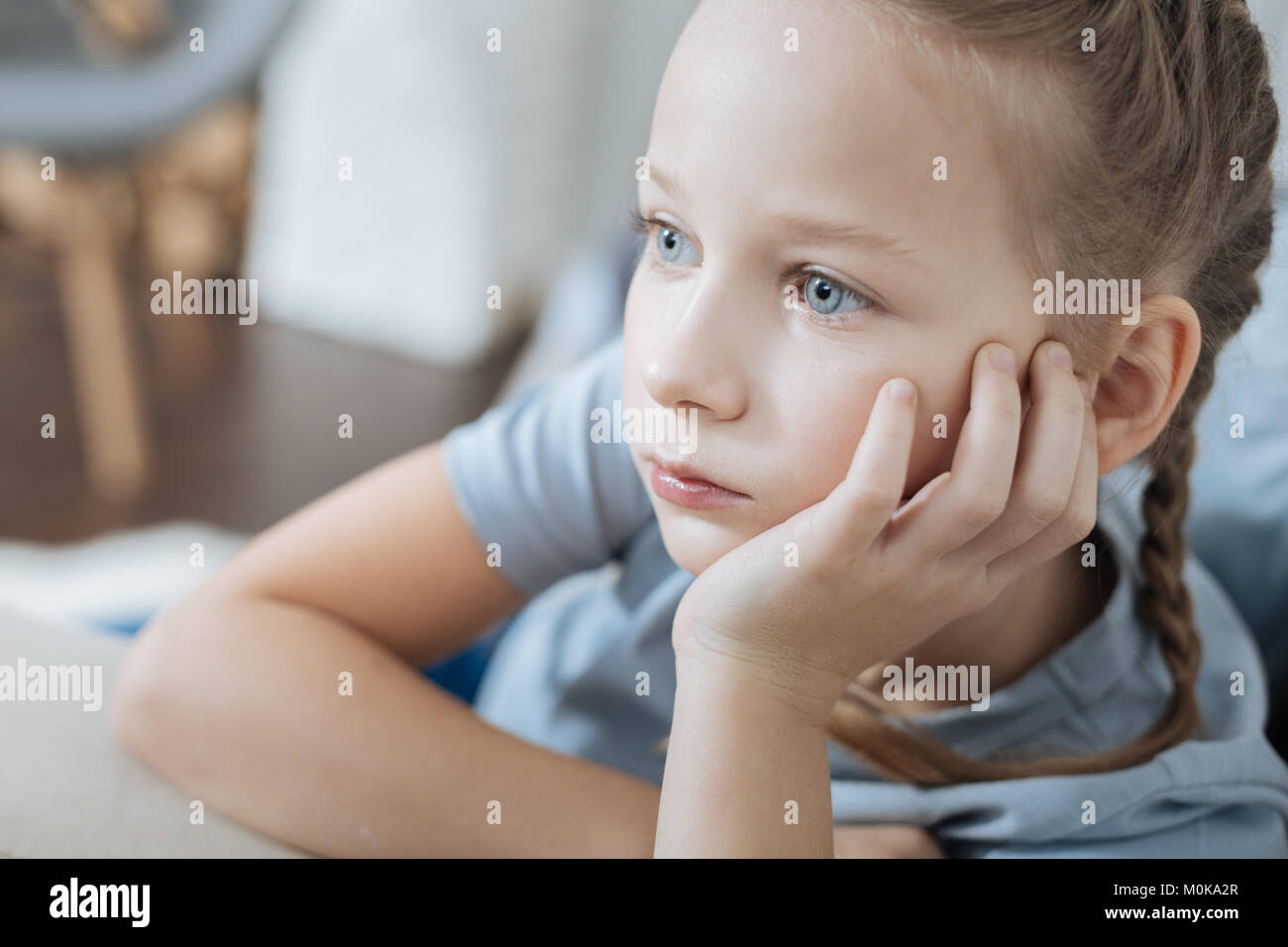 Concentrated little kid sitting and thinking Stock Photo - Alamy