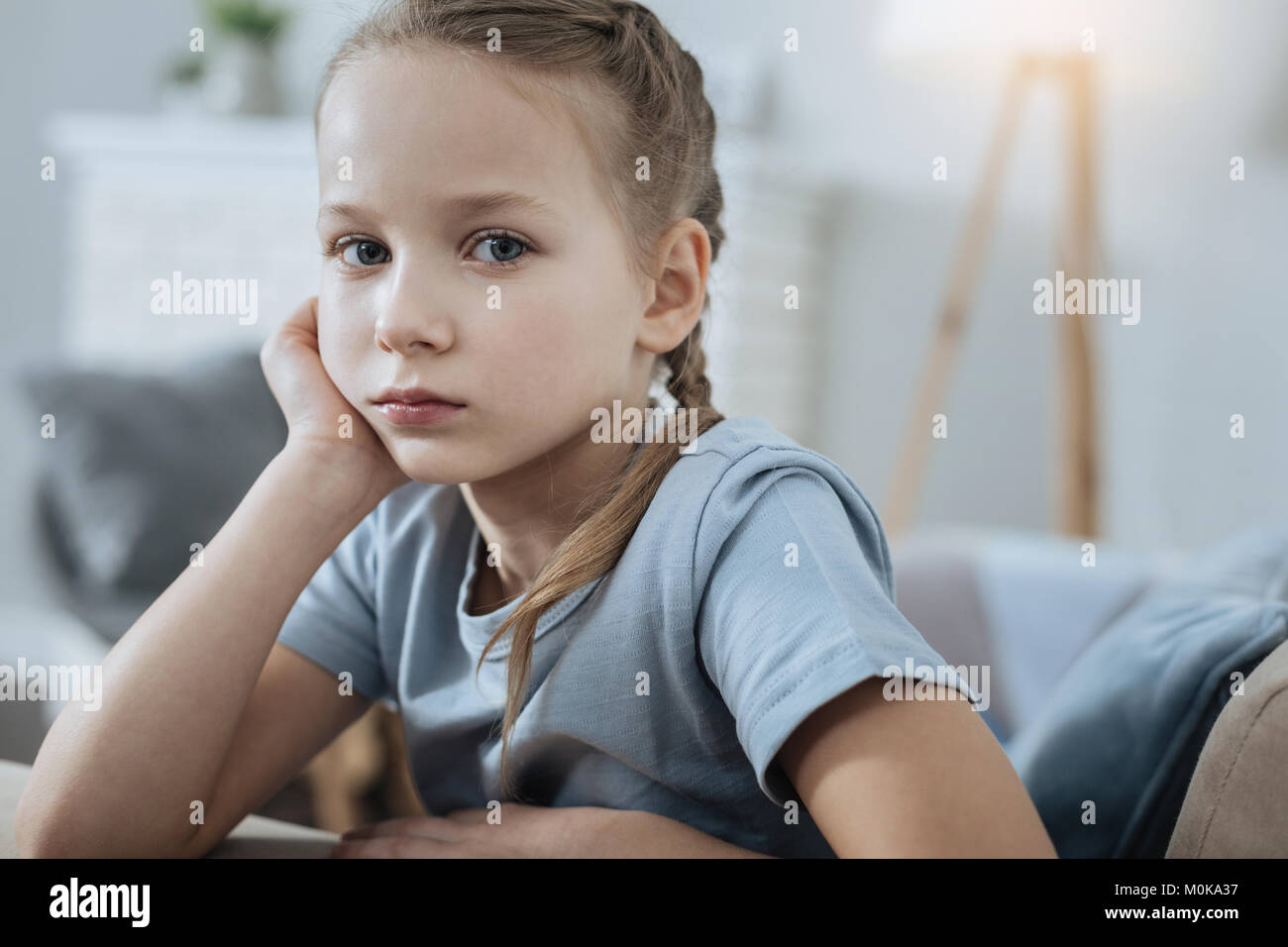 Unhappy child holding her head with her hand Stock Photo - Alamy