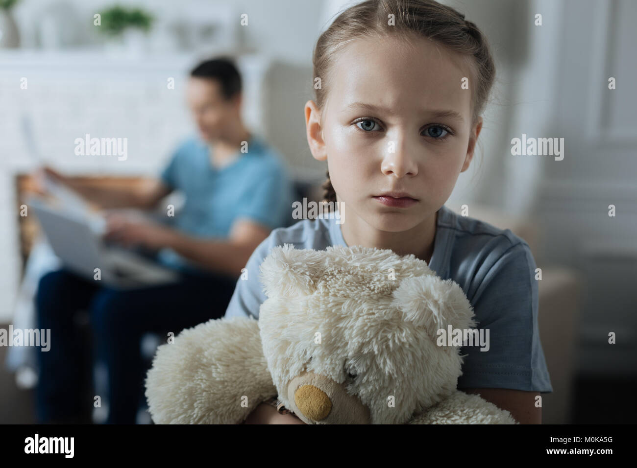 Sad little girl holding her toy Stock Photo - Alamy