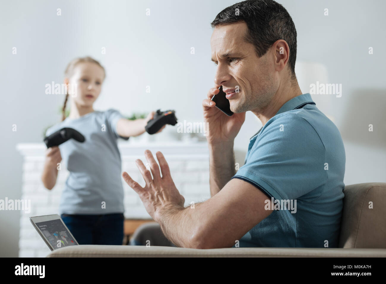 Busy dad having no time on playing with daughter Stock Photo - Alamy