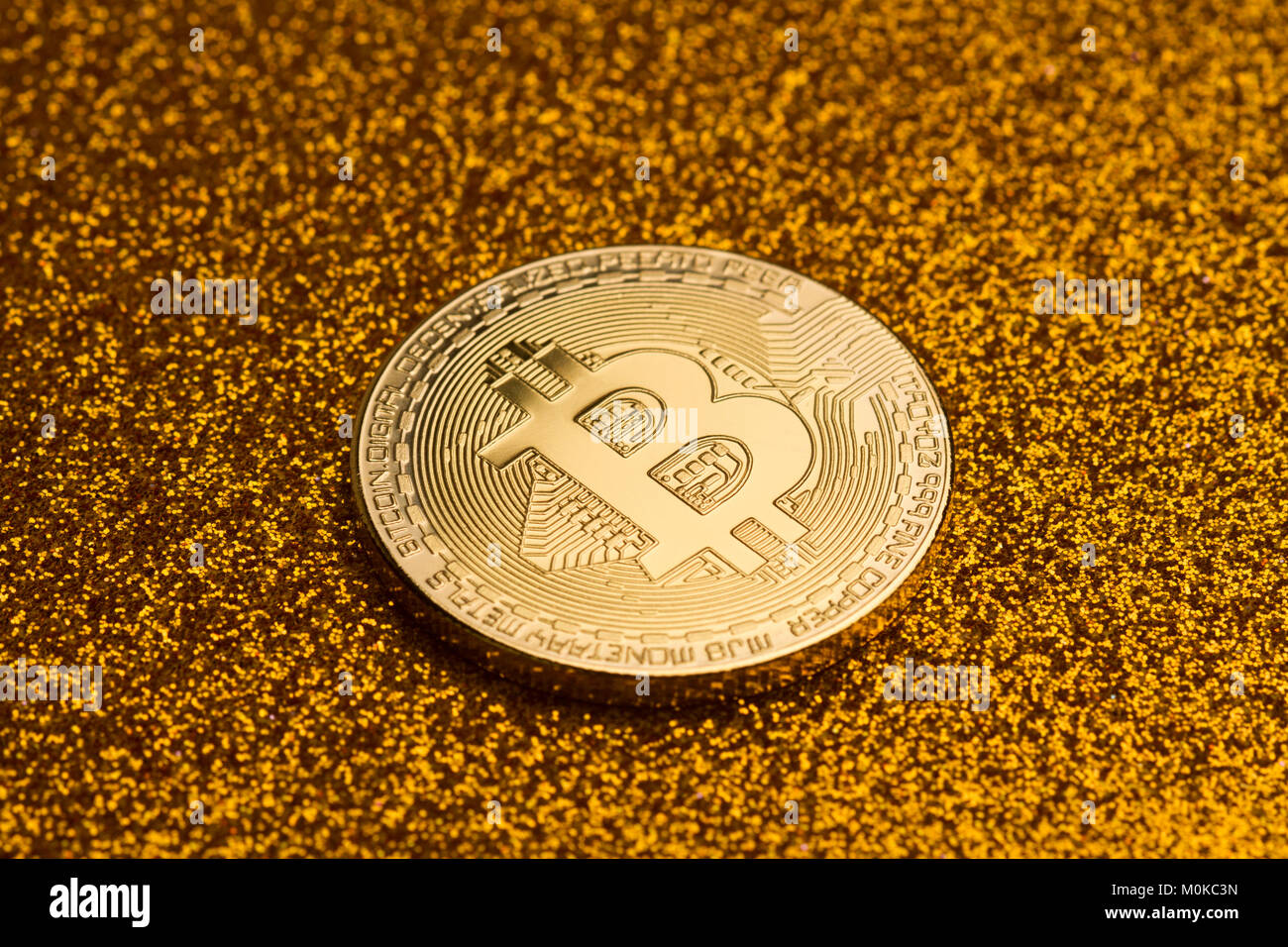 horizontal top view of single bitcoin coin on golden glittering ...