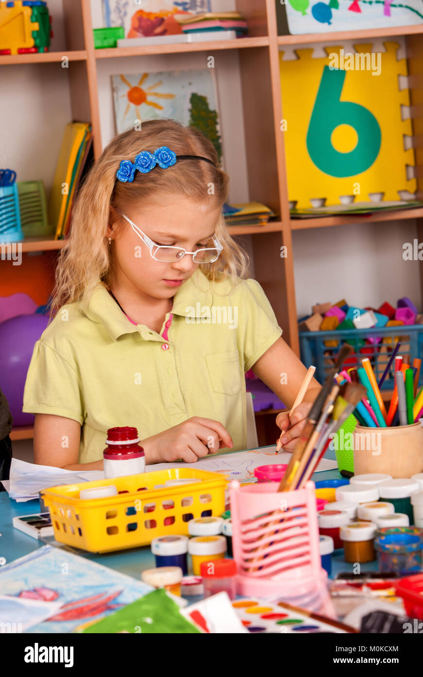 Small students painting in art school class. Child in spectacled ...