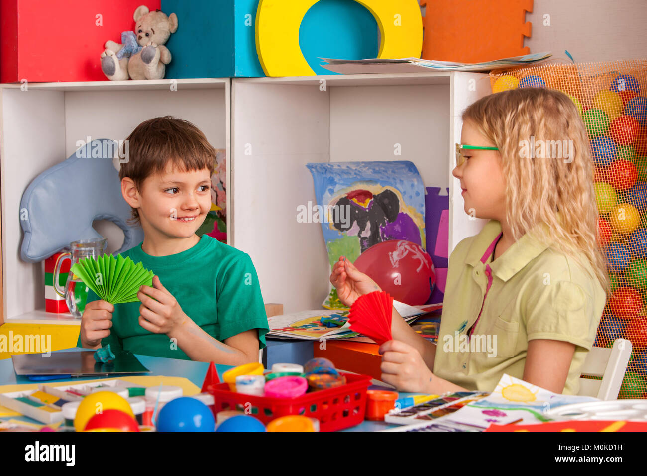 School children with paper in kids hands cutting paper Stock Photo - Alamy