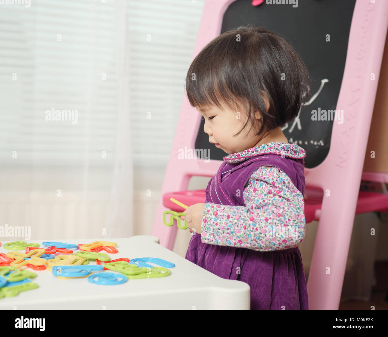 baby girl playing alphabet blocks at home Stock Photo - Alamy