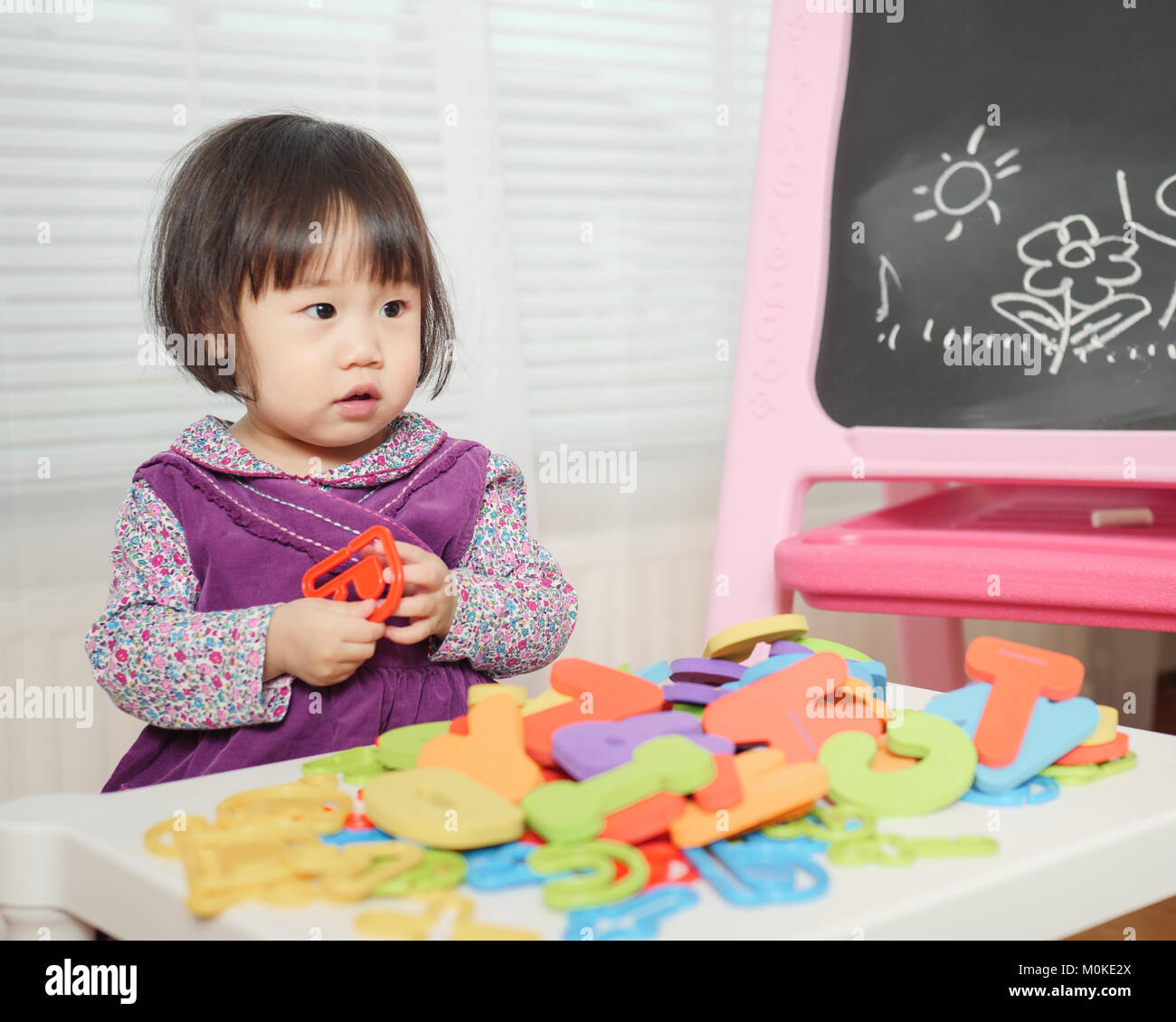 baby girl playing alphabet blocks at home Stock Photo - Alamy