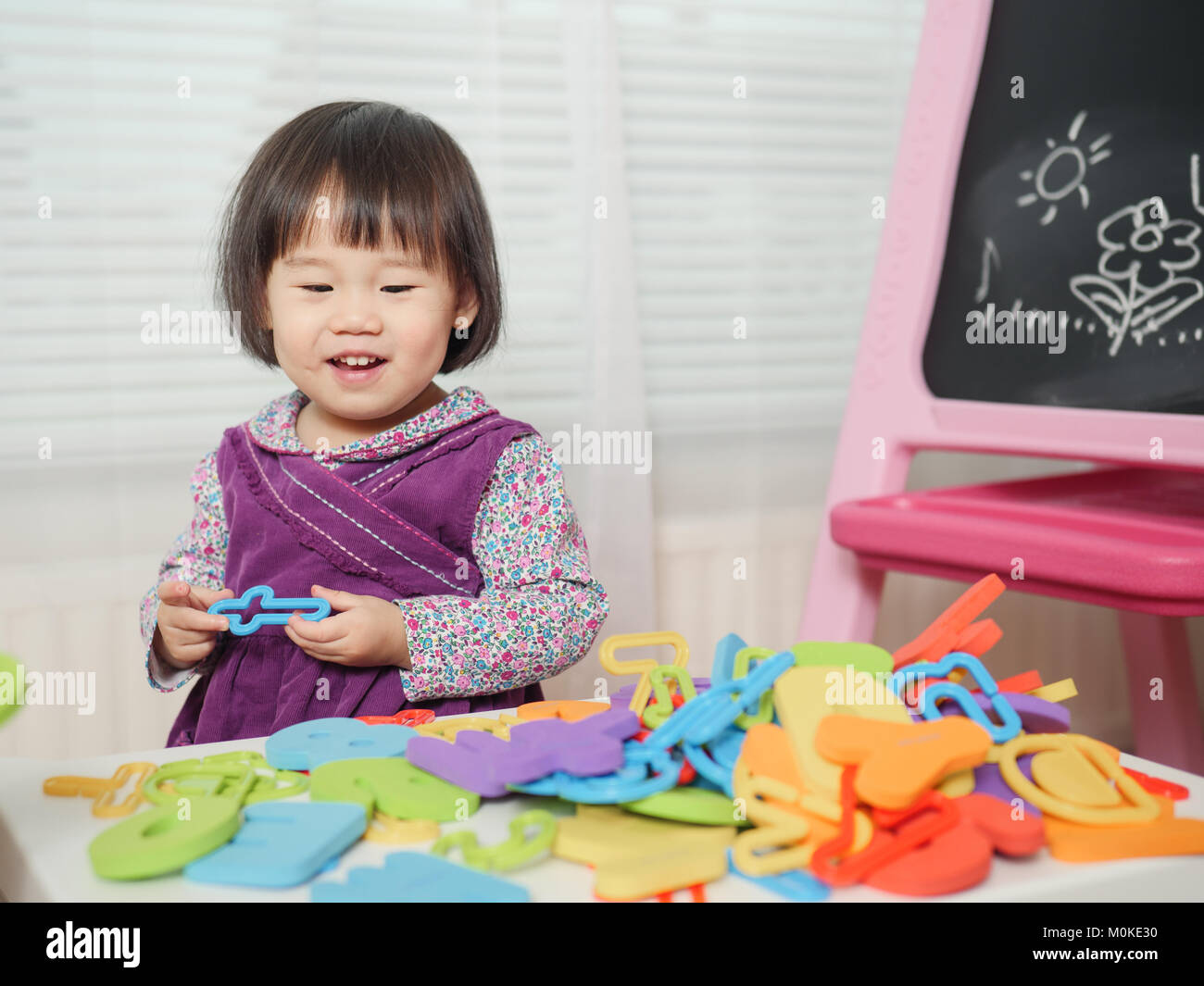 baby girl playing alphabet blocks at home Stock Photo - Alamy