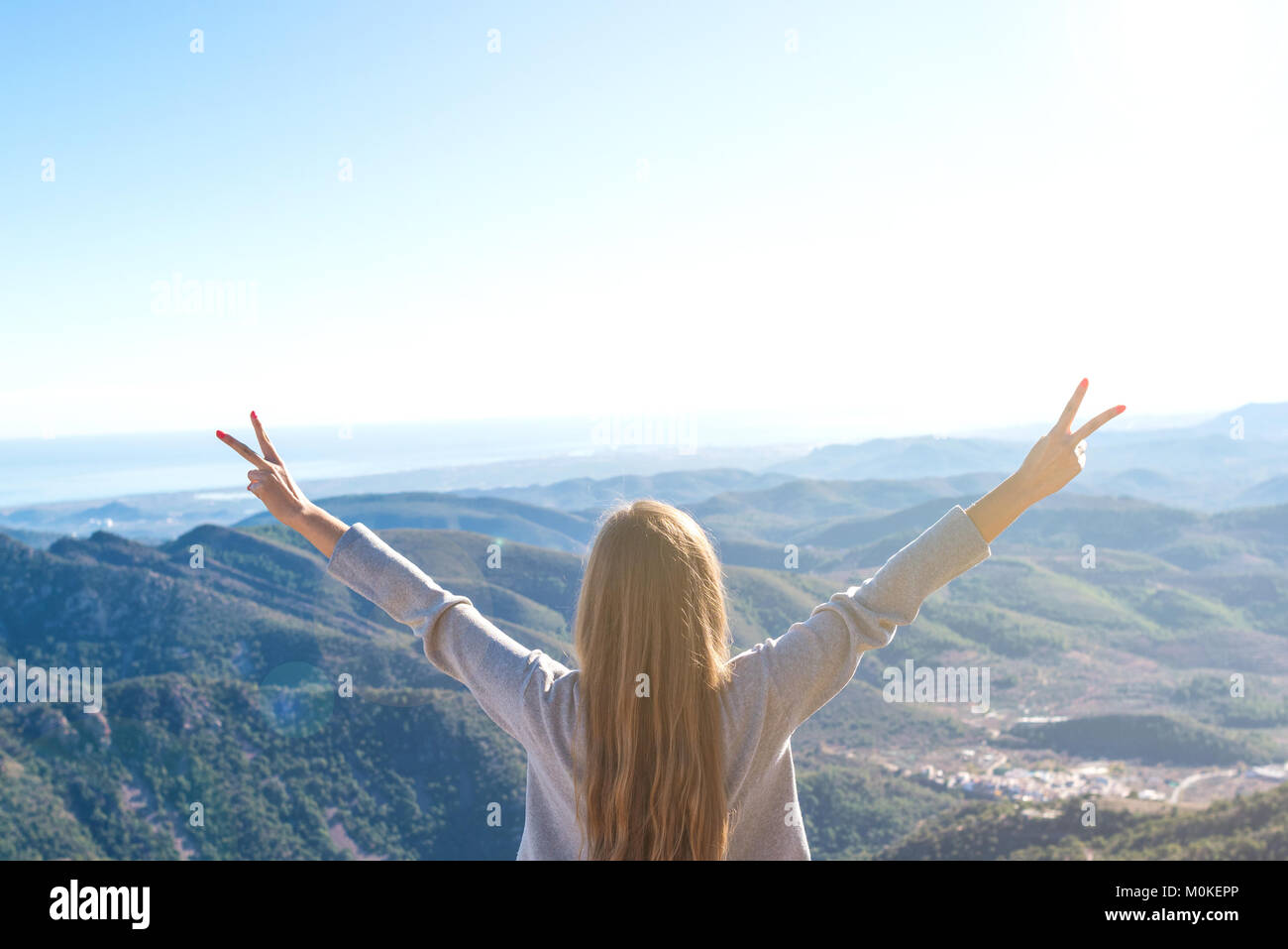 Beautiful women showing peace sign while enjoying mountains landscape ...