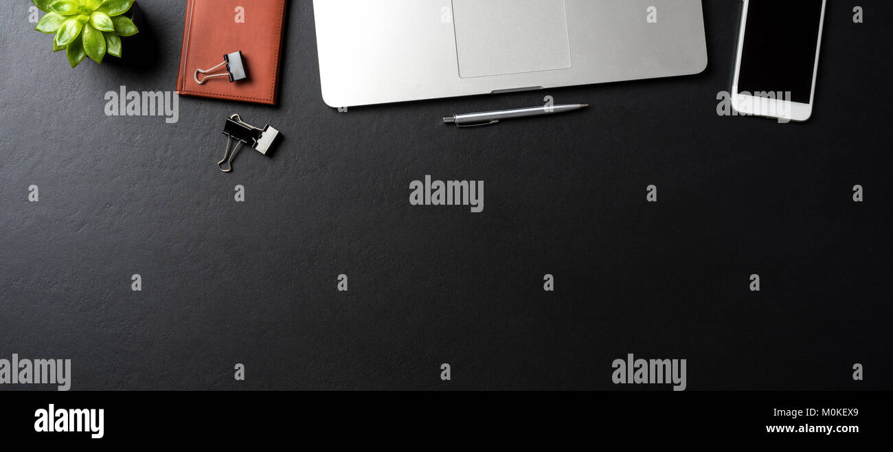 Black office desktop with laptop and accessories. Business background ...