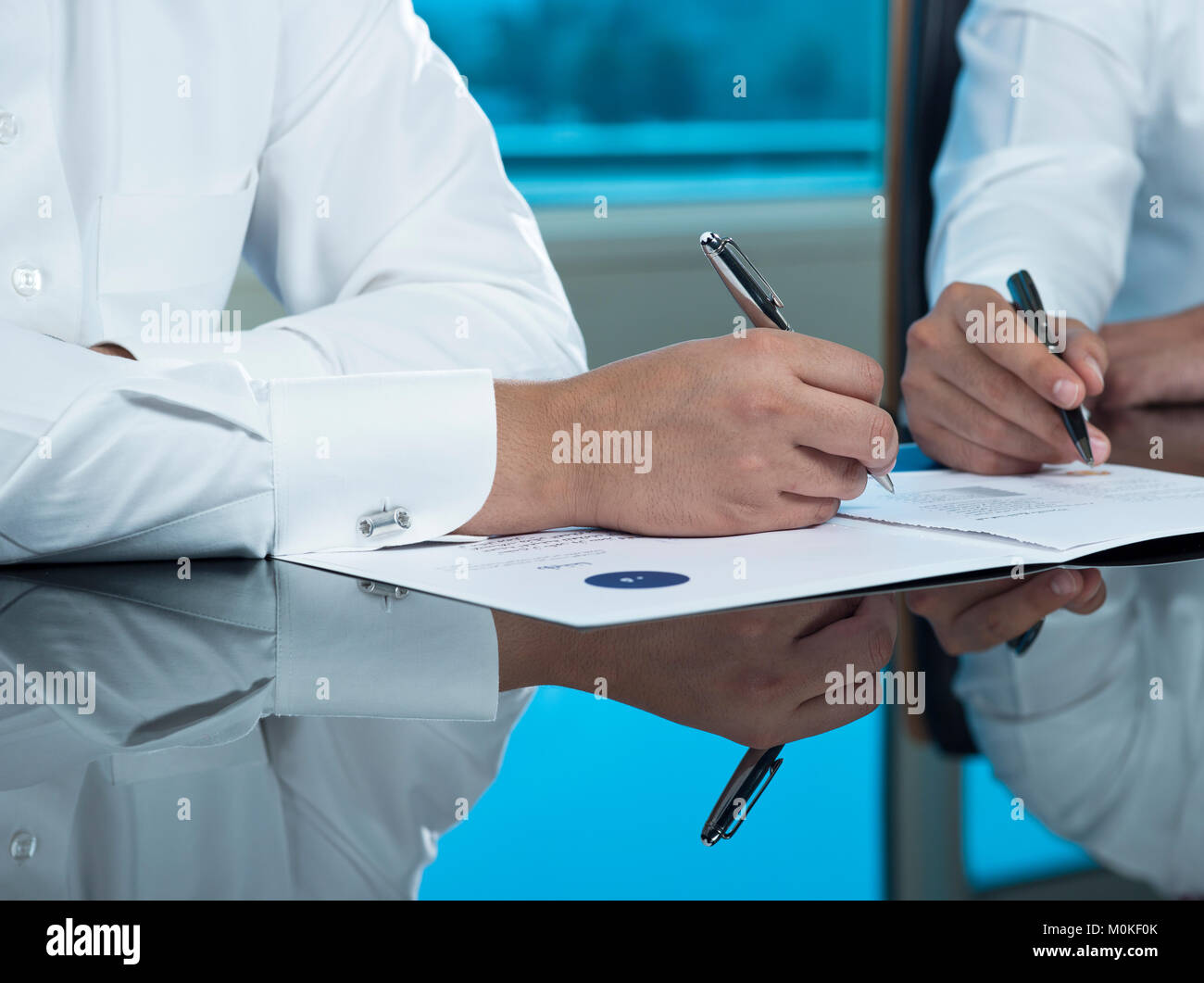 Two Saudi Businessmen Hands Signing a document, contract or making a ...