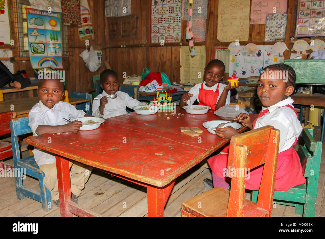 Four Nanyuki preparatory school children sitting around table while ...