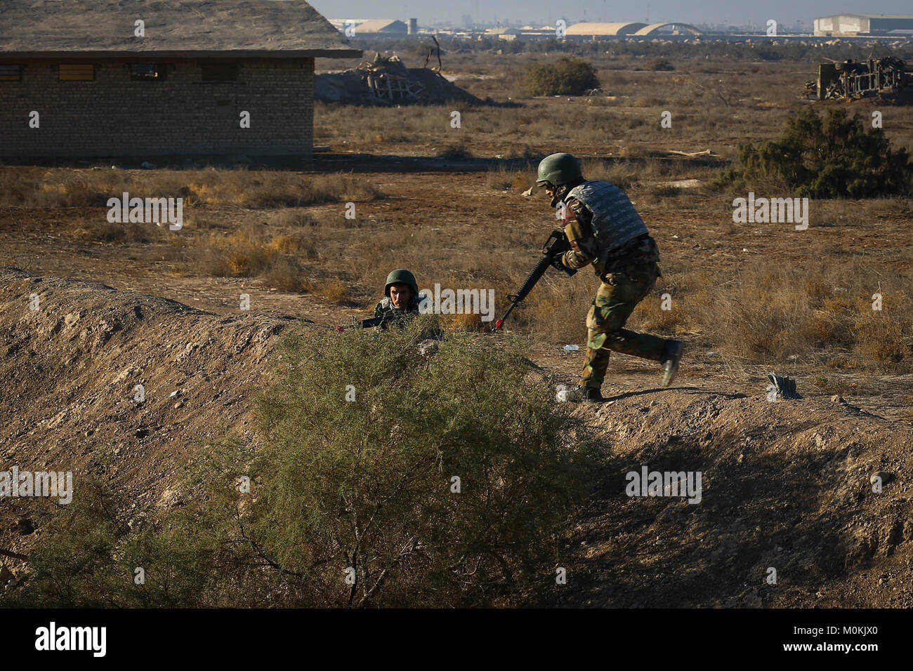 Iraqi Soldiers attached to the 57th Brigade proceed over a berm while ...