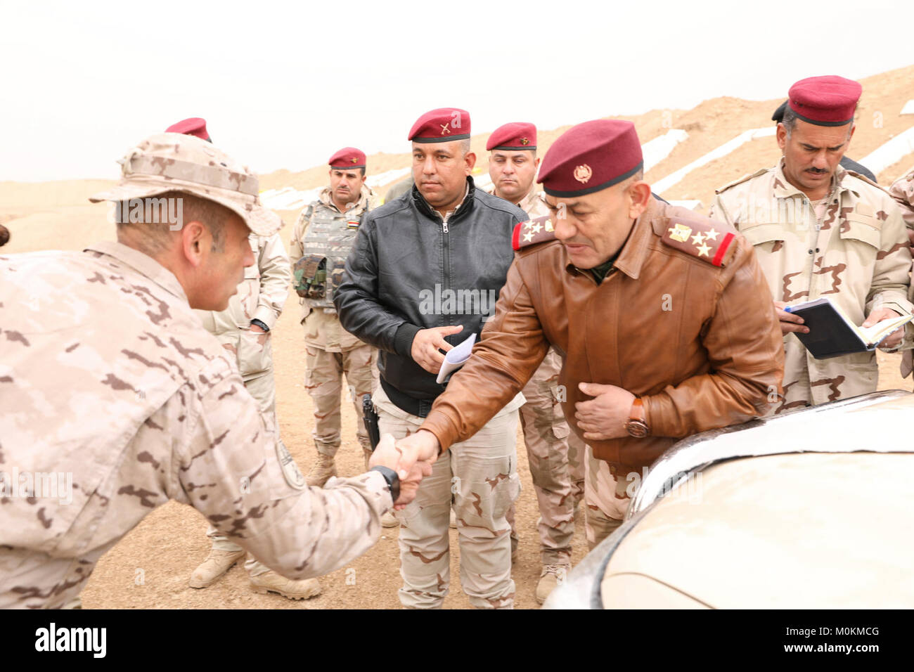 A Spanish army officer shakes hands with senior Iraqi army leaders ...