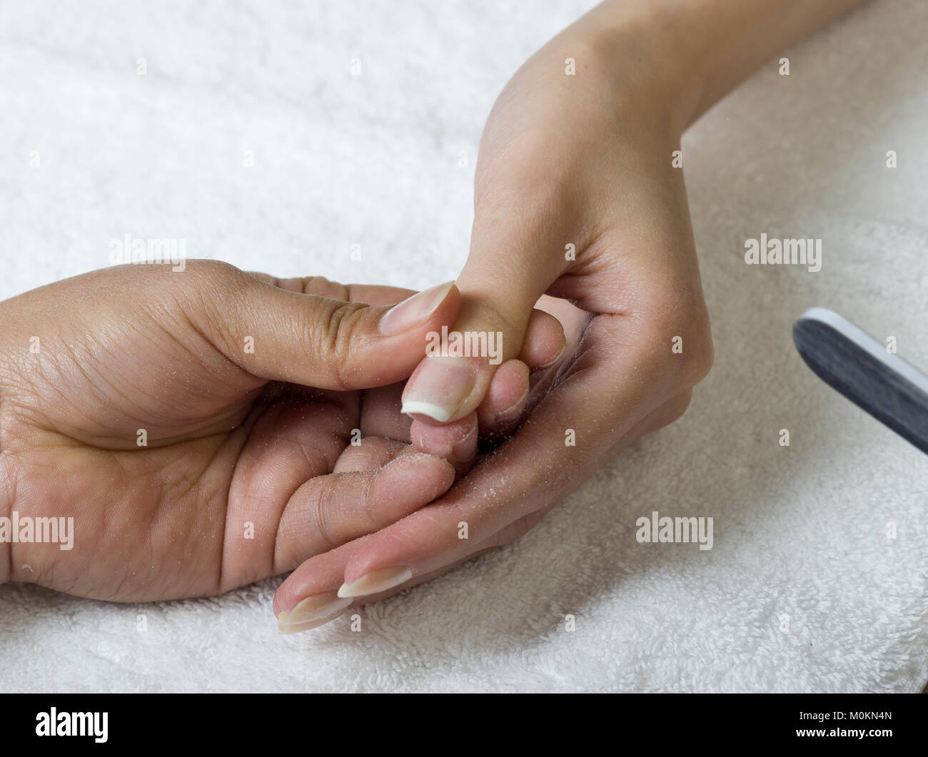 A close up of female hands doing manicure, applying glue for acrylic ...