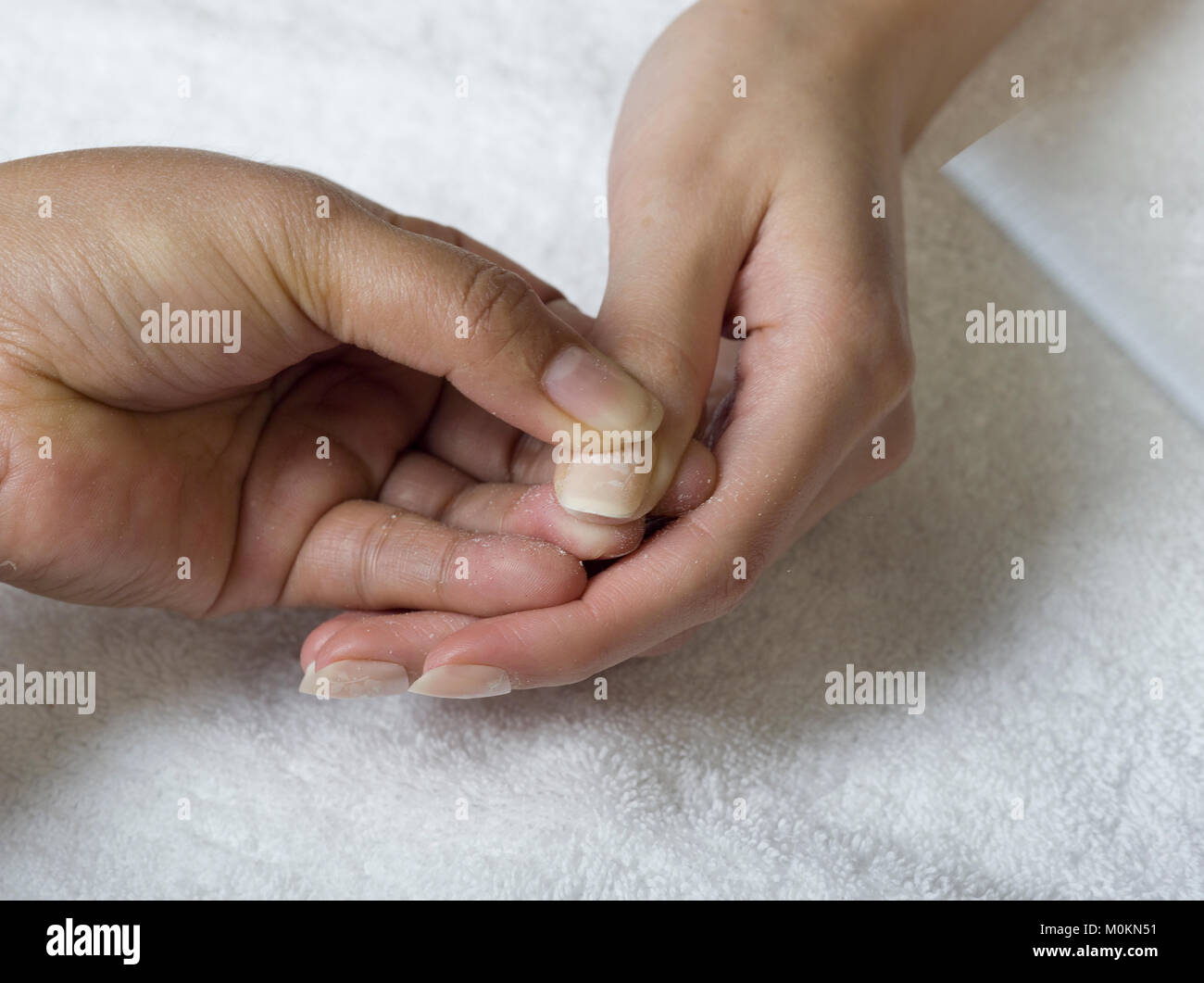 A close up of female hands doing manicure, applying glue for acrylic ...