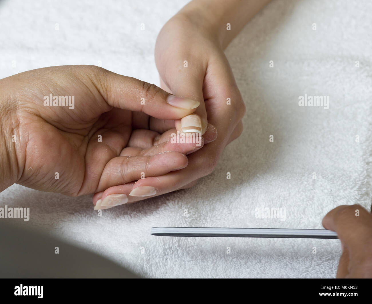 A close up of female hands doing manicure, applying glue for acrylic ...