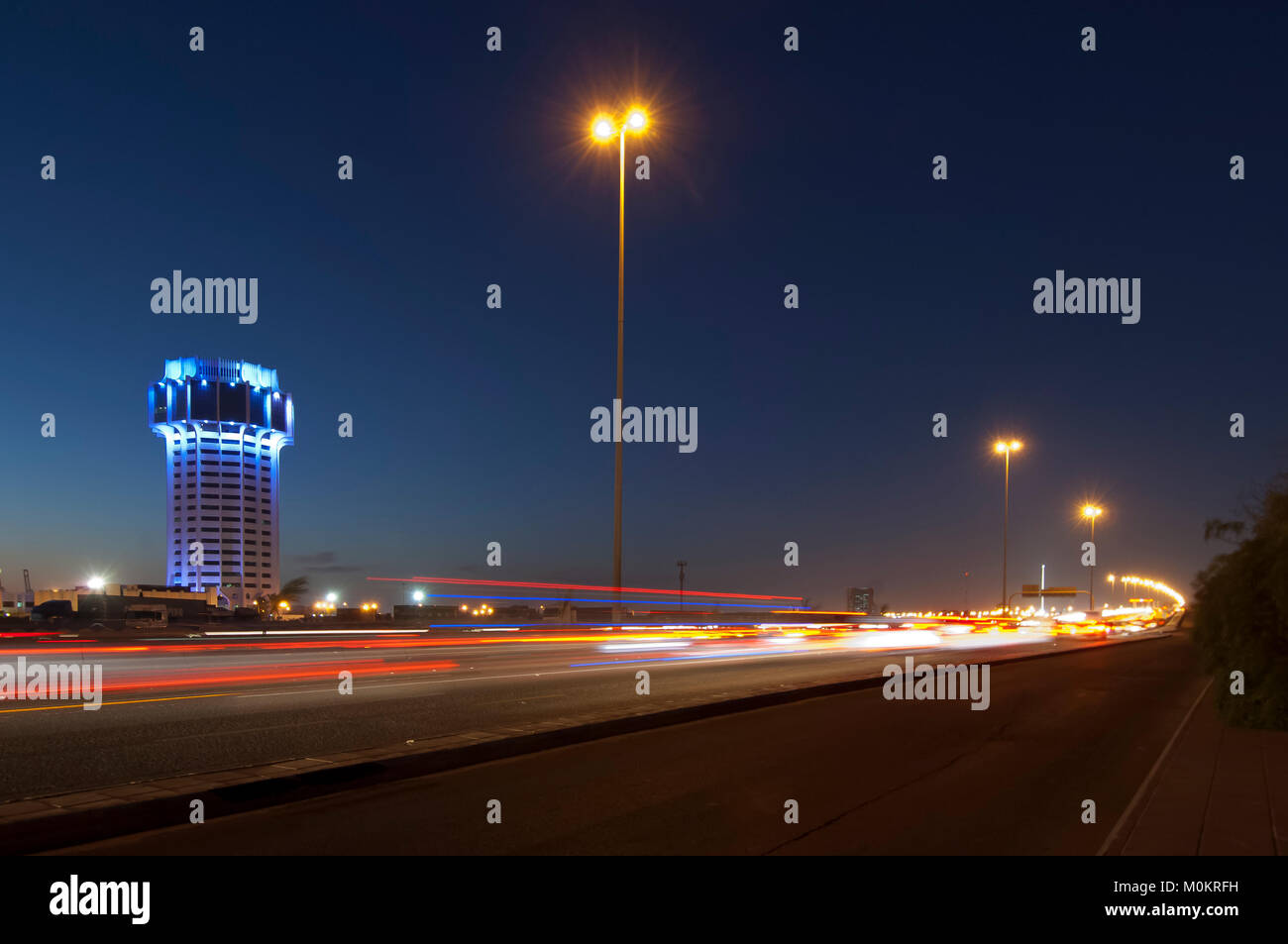 Jeddah water tower at night, with car lights motion on the street ...