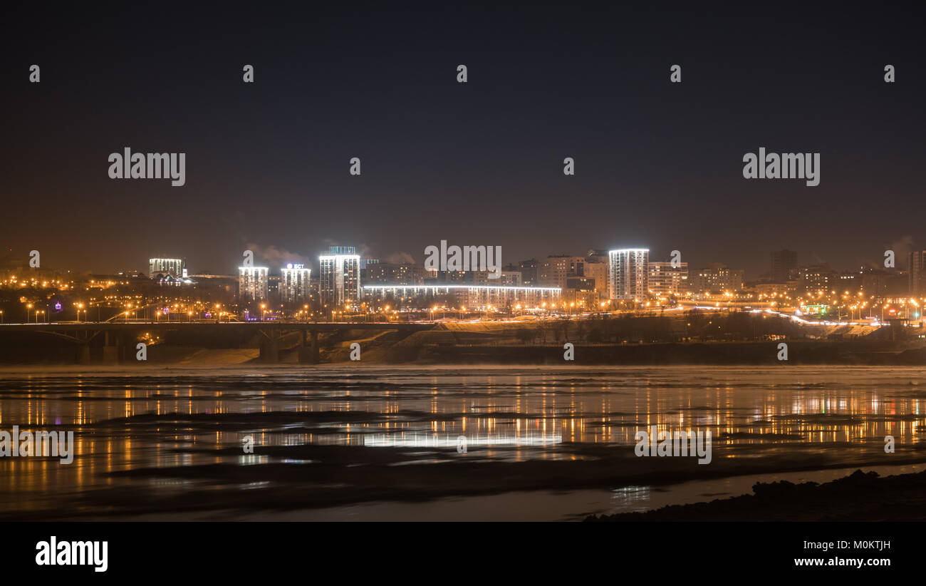 Evening view of city Ufa over White River covered with ice at winter ...