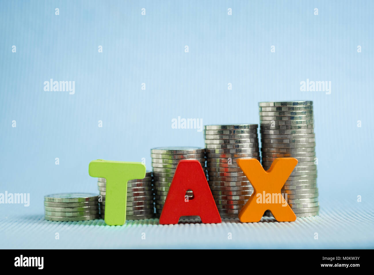 TAX concept. Word TAX alphabet made from wood with stack of coin ...