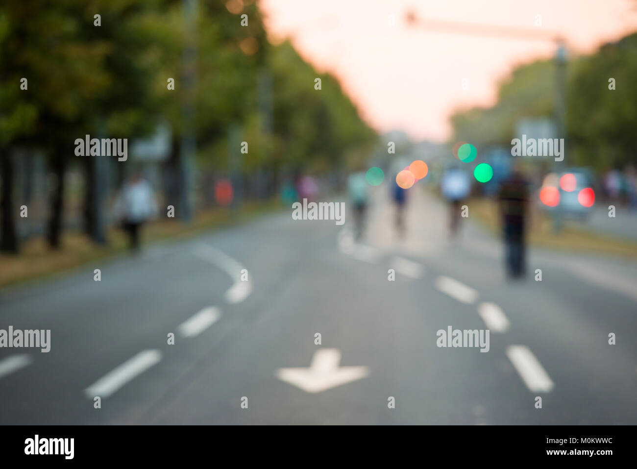 Blurry image of empty street without traffic with traffic lights in a ...