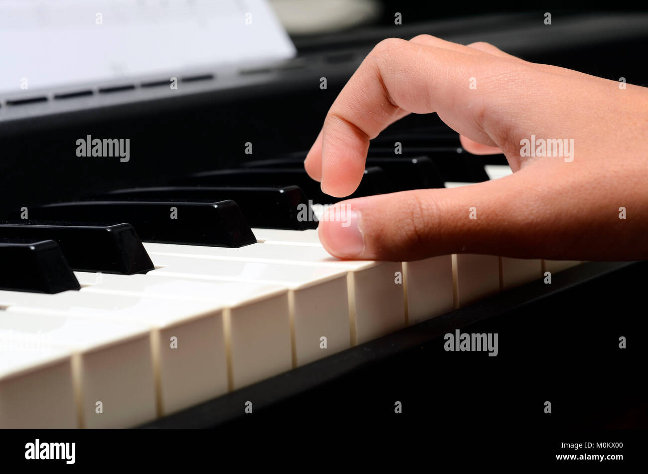 Child hands playing on piano keys, lateral view Stock Photo - Alamy