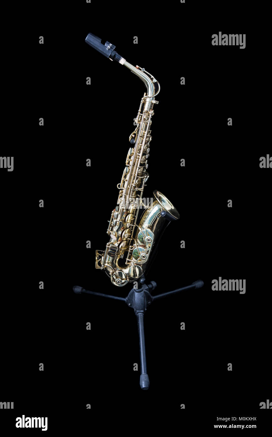 Full view of a golden saxophone standing isolated in black Stock Photo ...