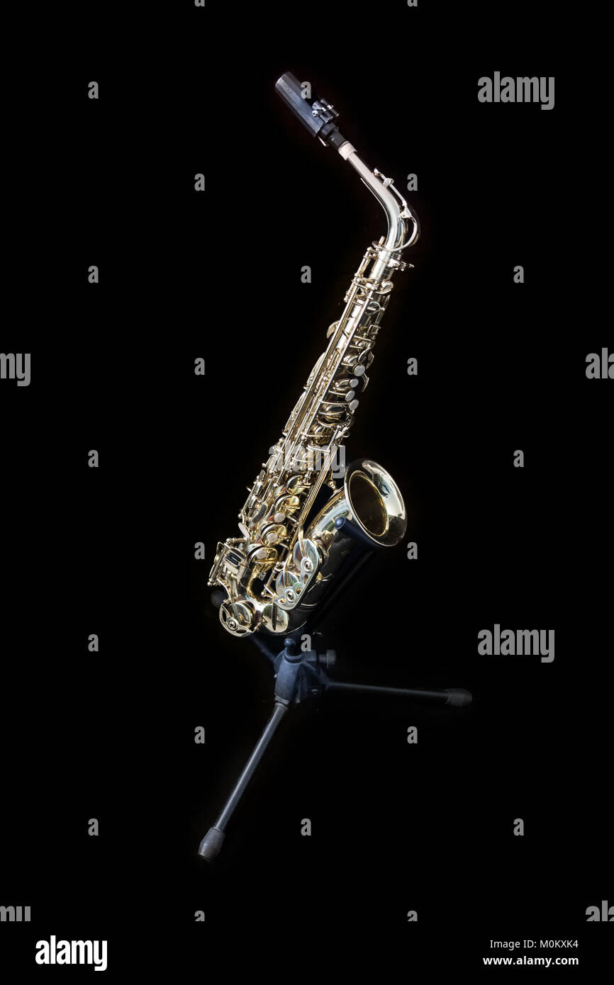 Full view of a golden saxophone standing isolated in black Stock Photo ...
