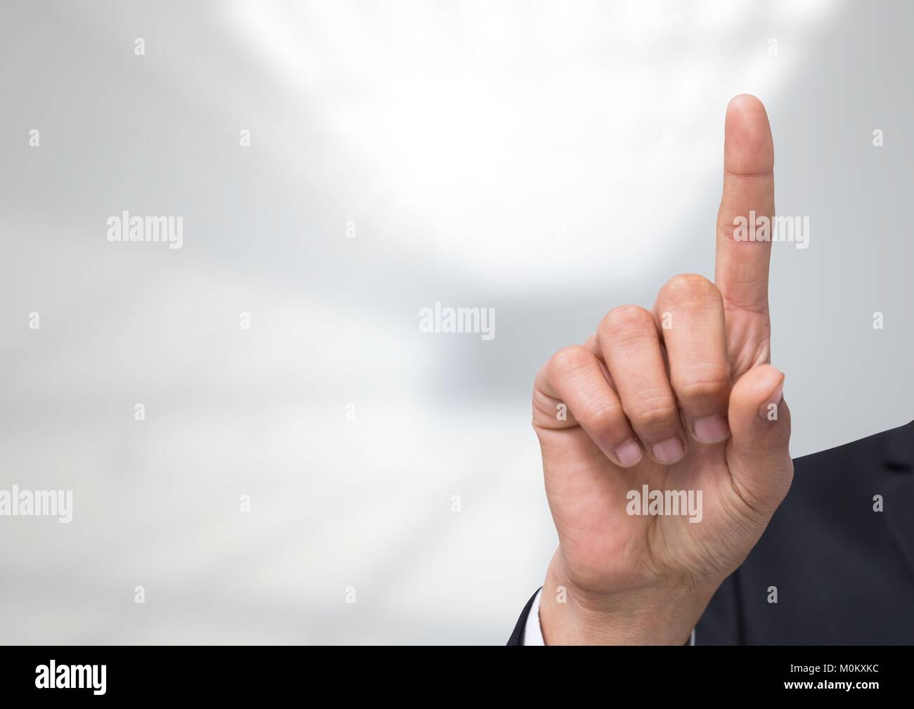 Hand pointing up with bright background Stock Photo - Alamy